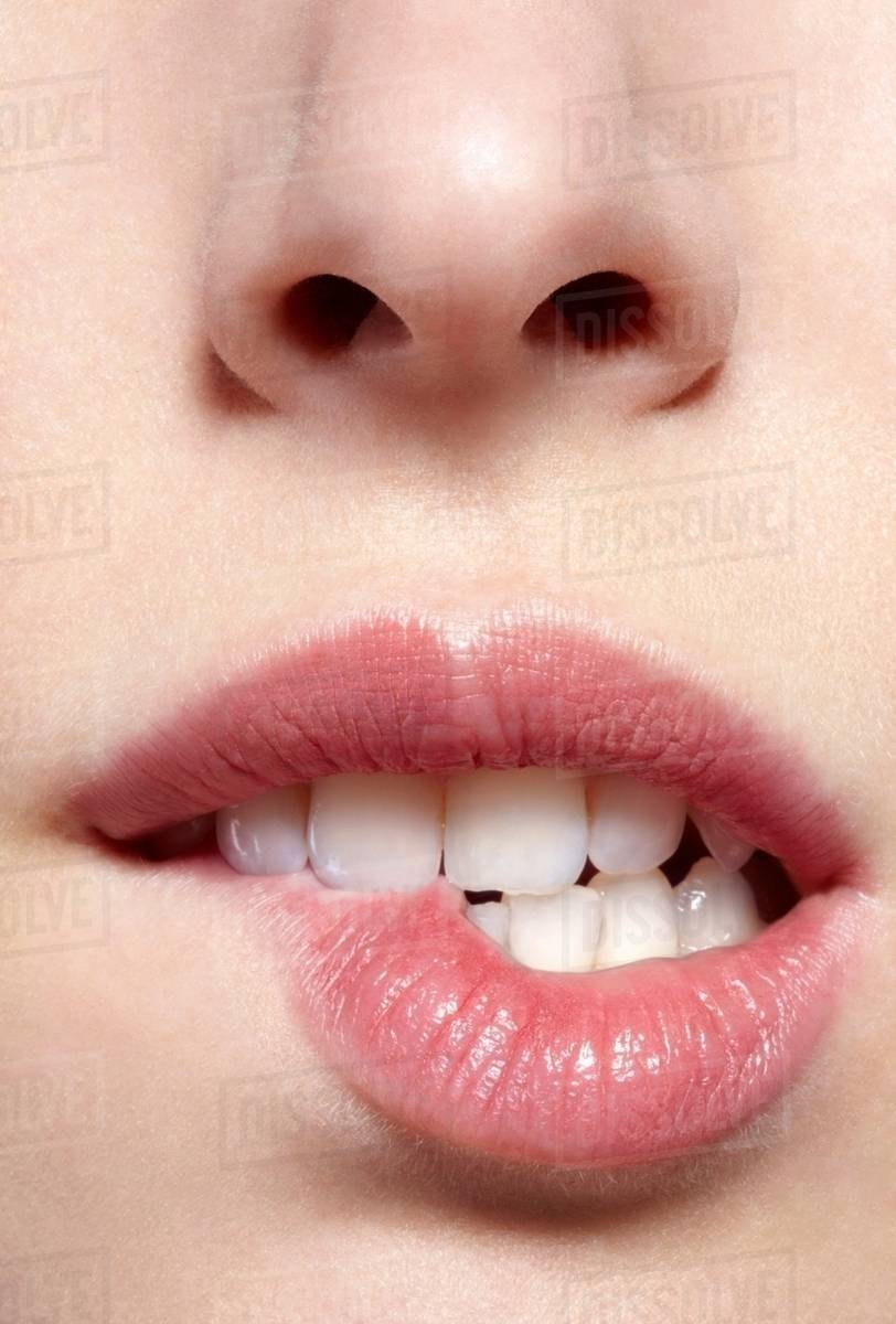 Close up of woman biting her lip - Stock Photo - Dissolve