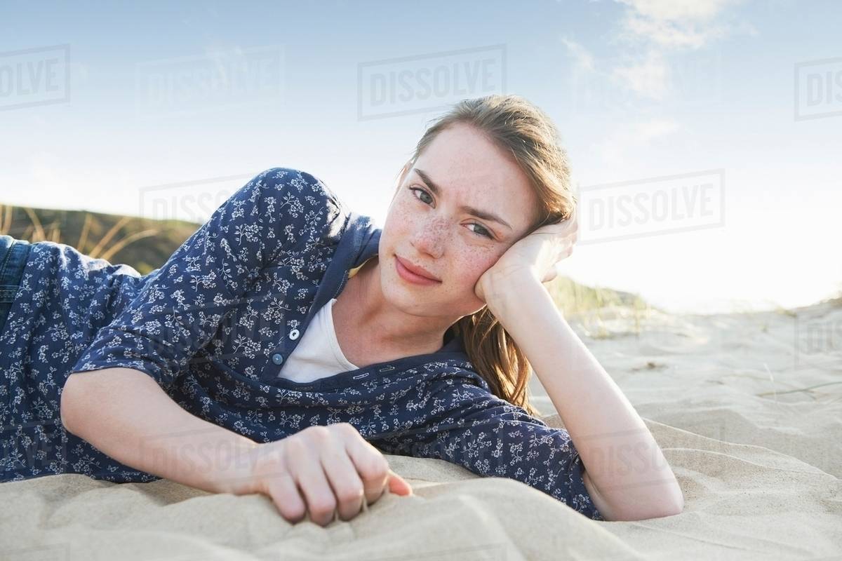 Teenage girl lying on beach - Royalty-free Stock Photo | Dissolve