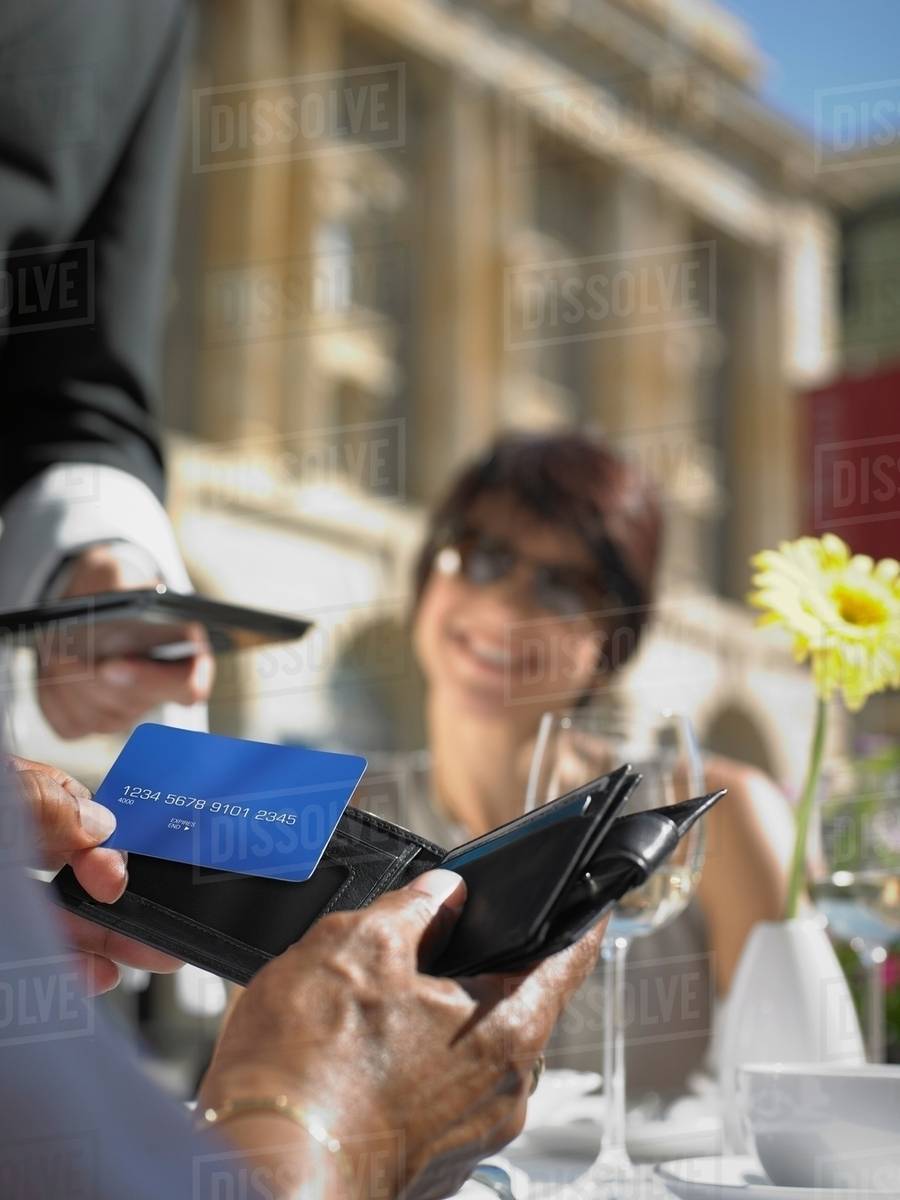Woman smiling at friend making credit card payment - Royalty-free Stock ...