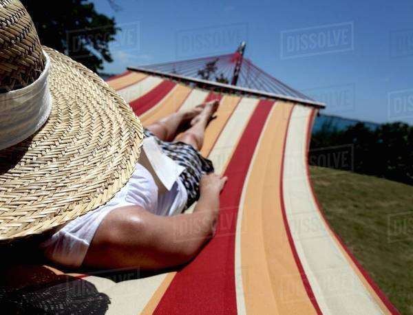 Woman relaxing on hammock - Stock Photo - Dissolve