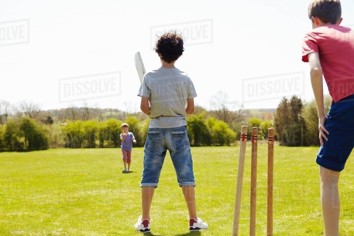 Boys playing cricket on field - Royalty-free Stock Photo | Dissolve