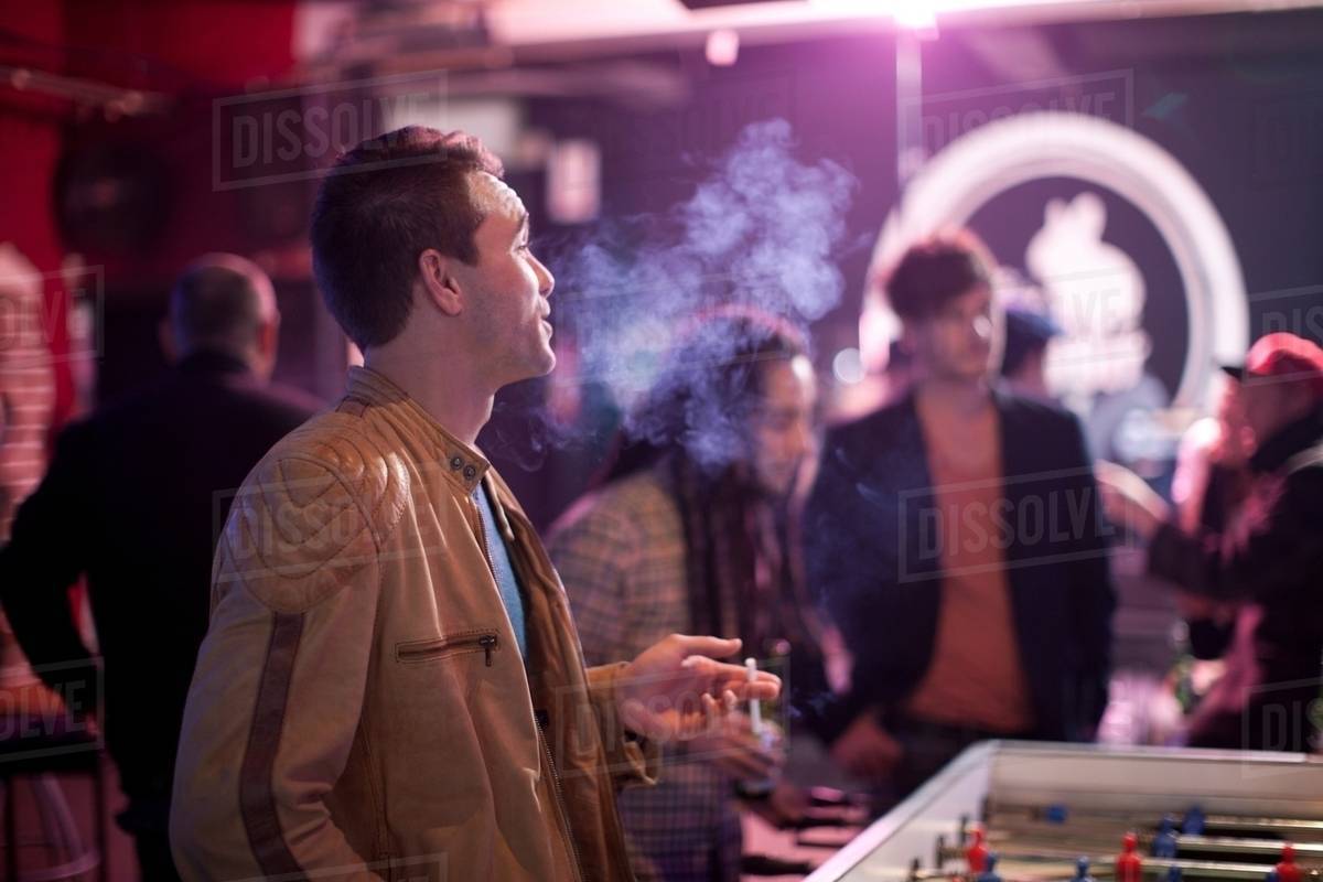 Man smoking cigarette in bar - Royalty-free Stock Photo | Dissolve
