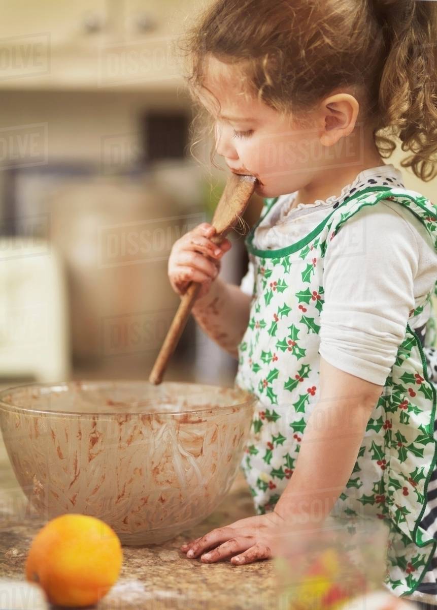 Child tasting cake mix with wooden spoon - Royalty-free Stock Photo ...