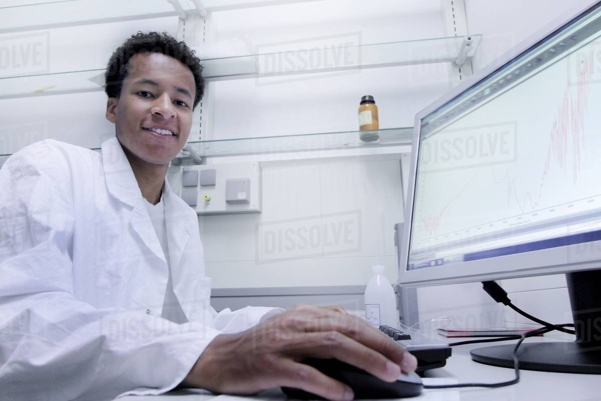Scientist wearing lab coat working on computer - Royalty-free Stock ...
