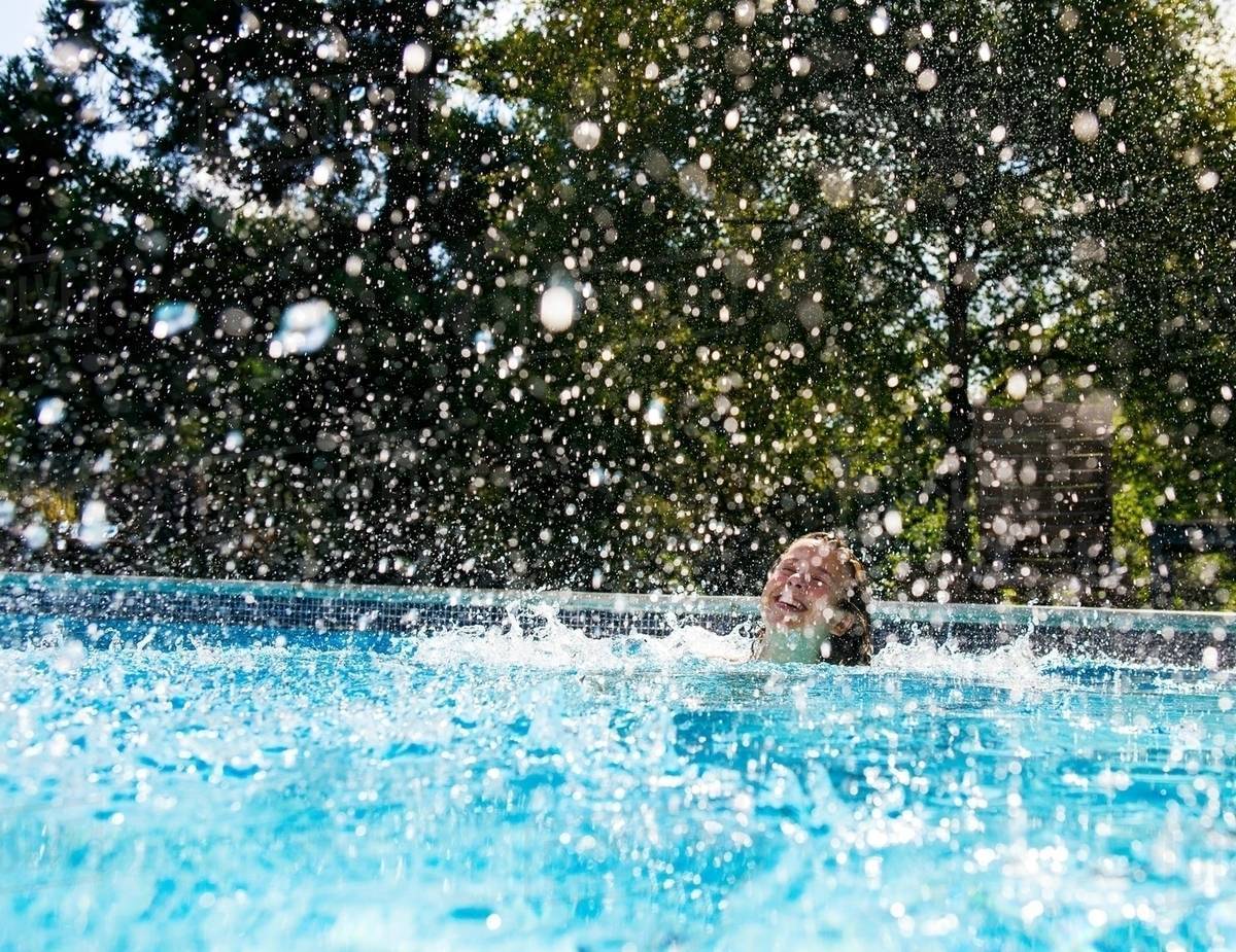 Girl splashing in swimming pool - Stock Photo - Dissolve