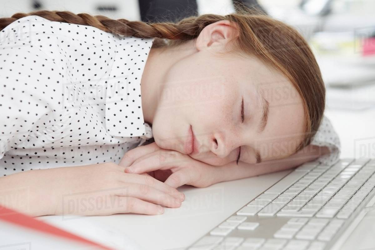 Girl asleep on computer keyboard - Royalty-free Stock Photo | Dissolve