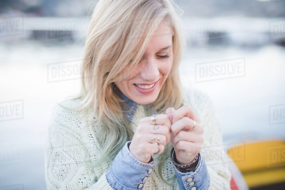 Young woman fiddling with hands on lakeside, Lake Como, Italy - Royalty ...