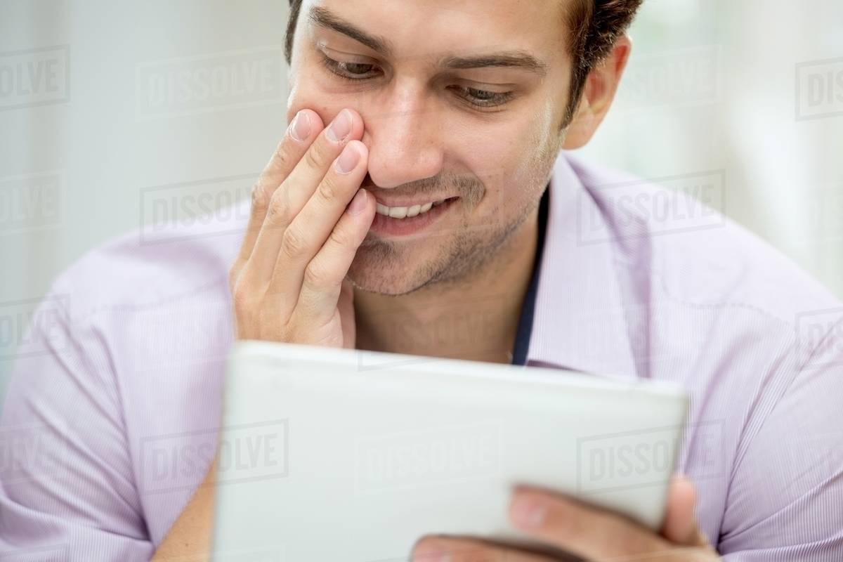 Young man looking at message on digital tablet - Royalty-free Stock ...