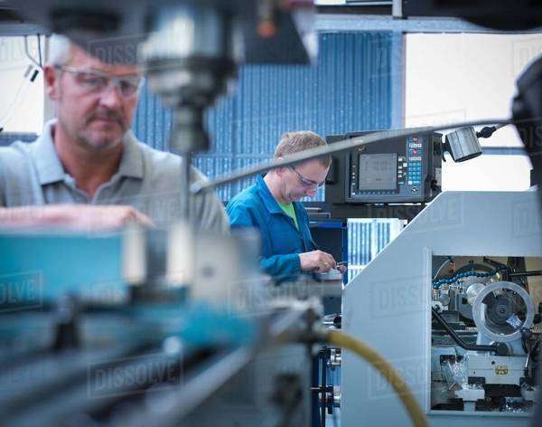 Lathe operators working in factory - Stock Photo - Dissolve