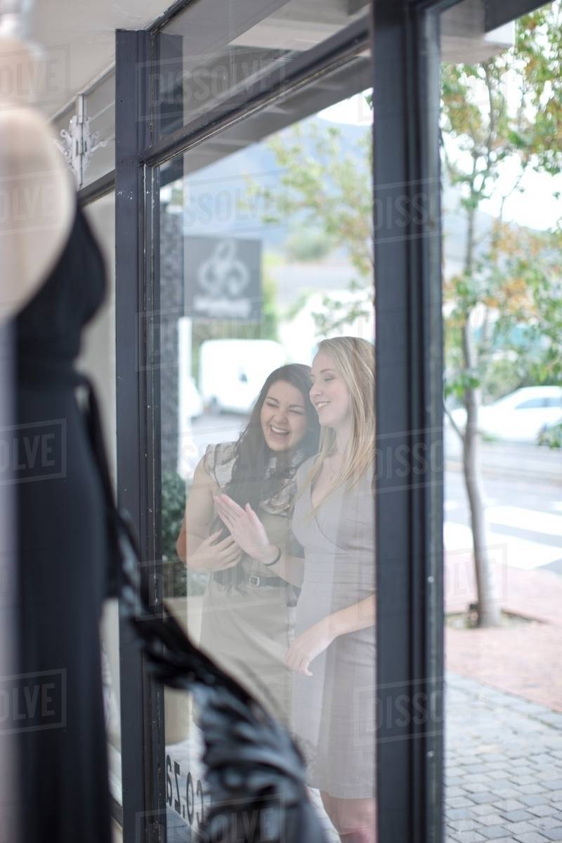 Friends window shopping, looking through shop front - Stock Photo ...