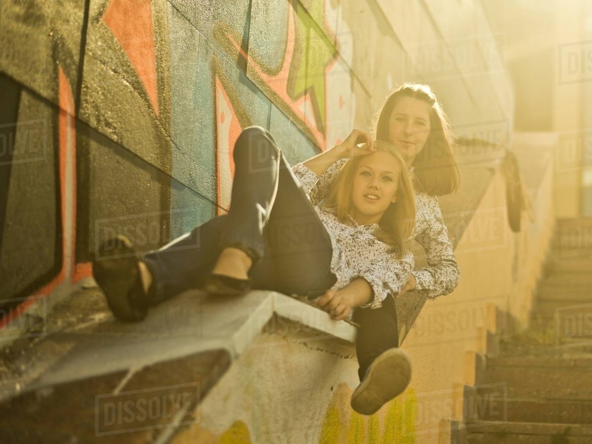 Two young women reclining on stairway - Royalty-free Stock Photo | Dissolve