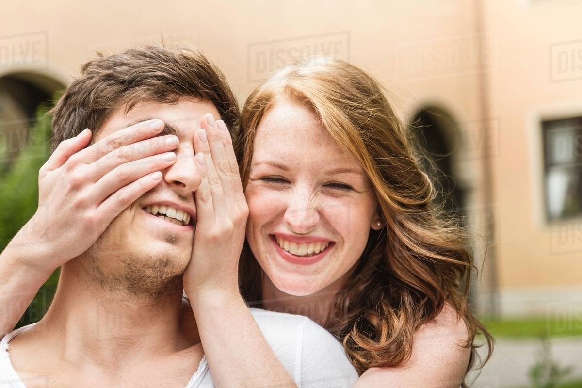 Young woman covering boyfriend's eyes - Stock Photo - Dissolve
