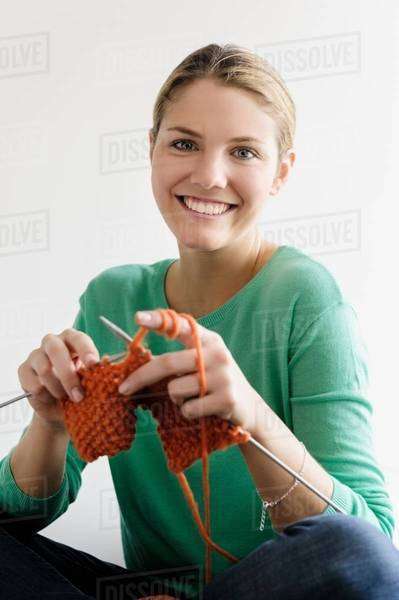 Portrait of young woman knitting - Stock Photo - Dissolve