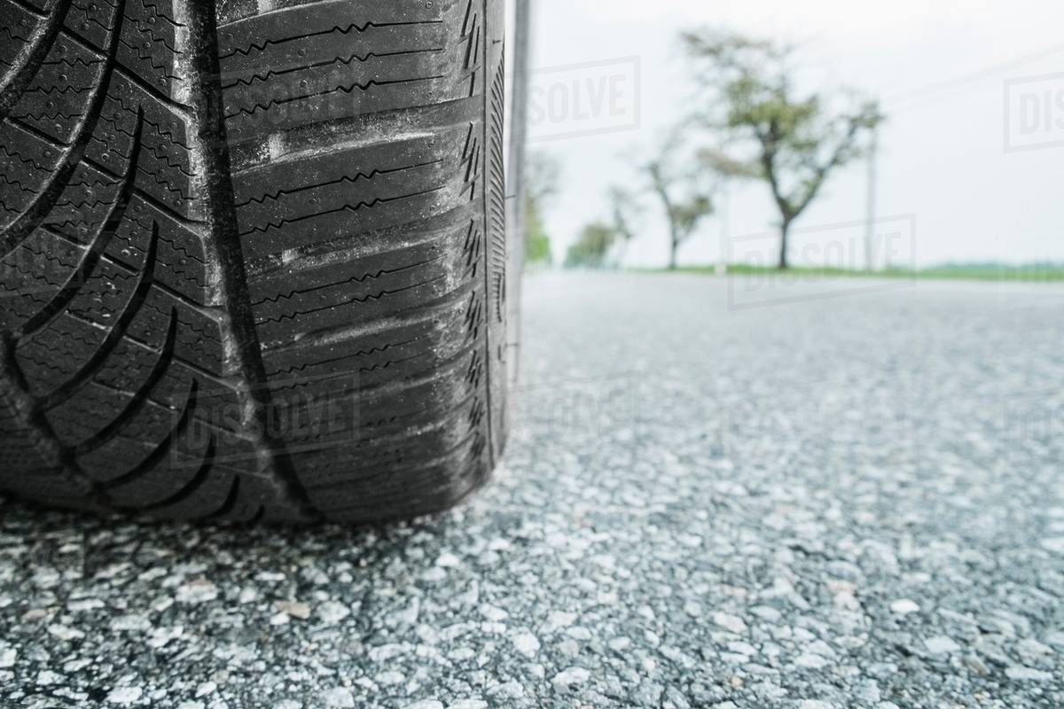 Car tire on road, close up - Royalty-free Stock Photo | Dissolve