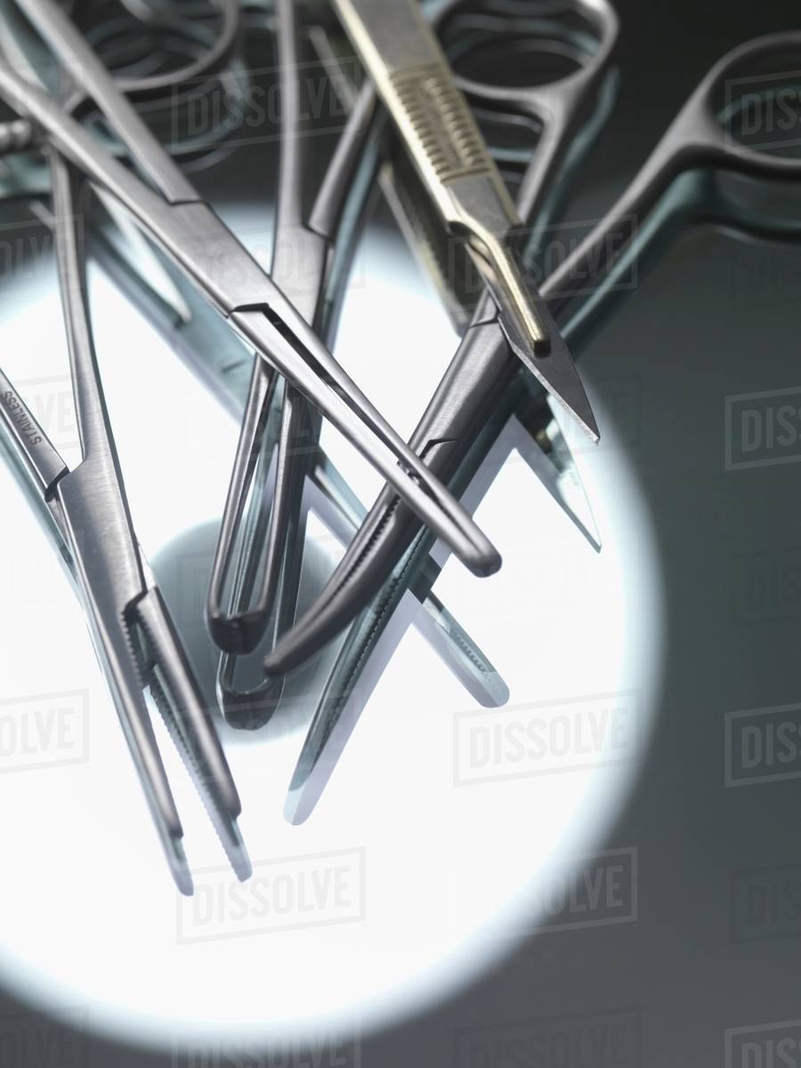 Surgical instruments on sterile tray with reflection of theatre light ...