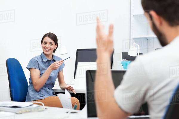 Two colleagues talking in office - Stock Photo - Dissolve