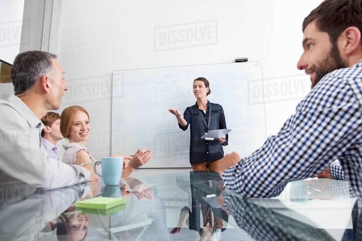 Businesswoman presenting to colleagues - Stock Photo - Dissolve