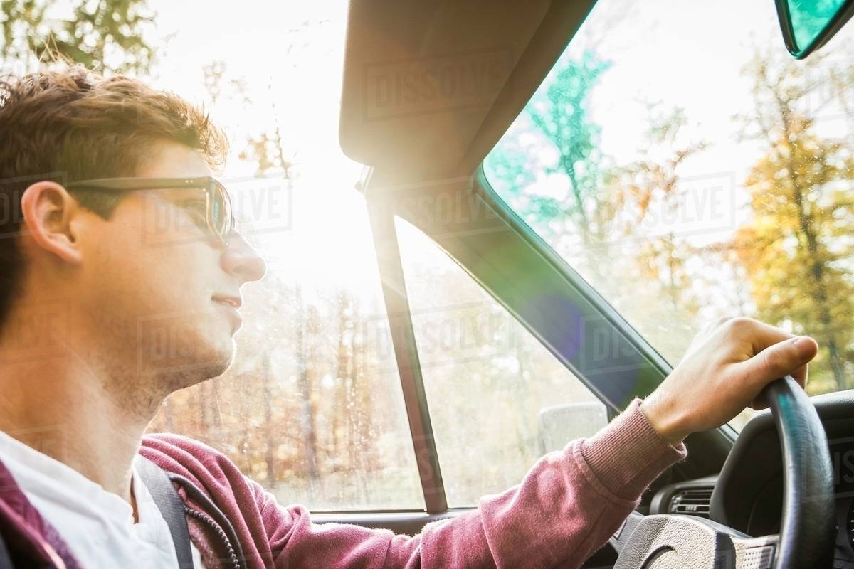Young man leaning driving convertible on country road - Stock Photo ...