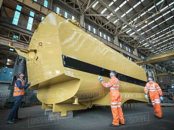 Engineers inspecting large tank in factory - Stock Photo - Dissolve