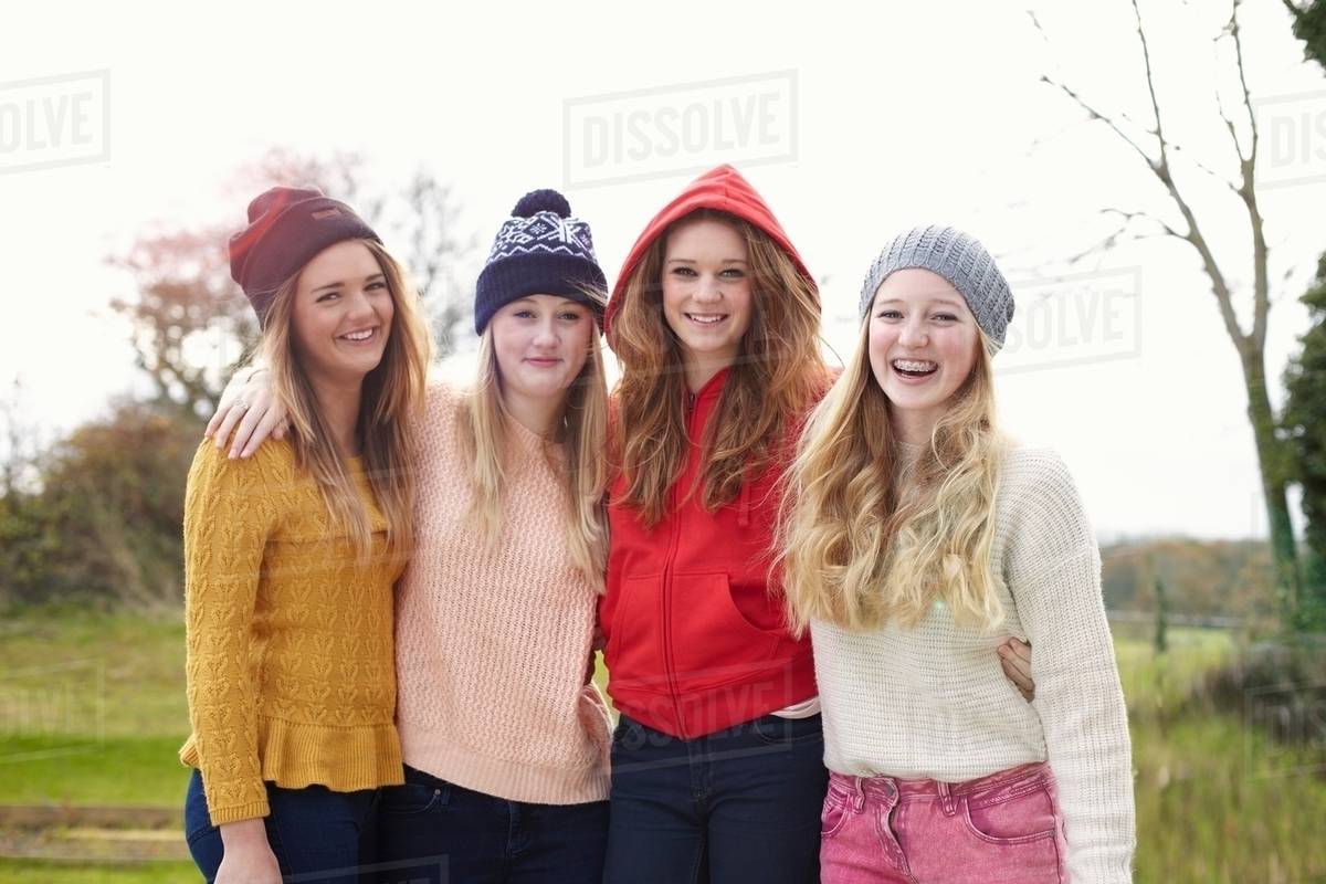 Portrait of four teenage girls in knitted hats - Stock Photo - Dissolve