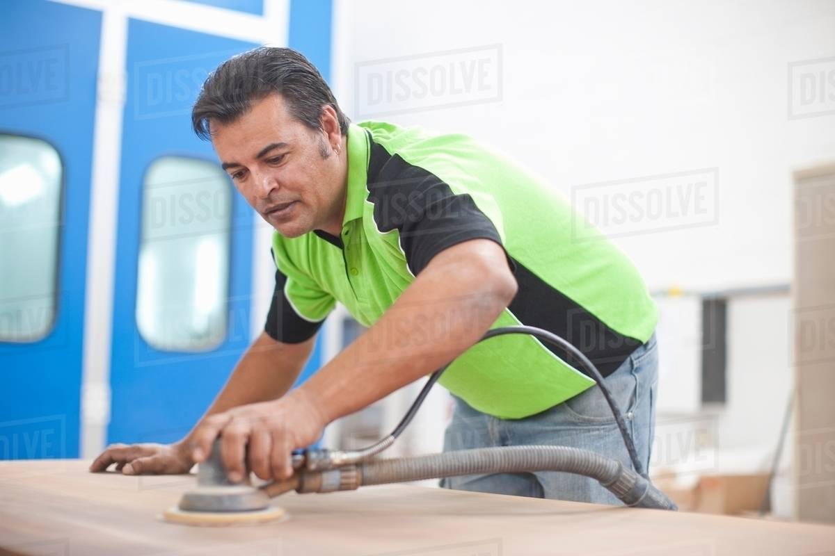 Man sanding down plank of wood in carpenters workshop - Royalty-free ...