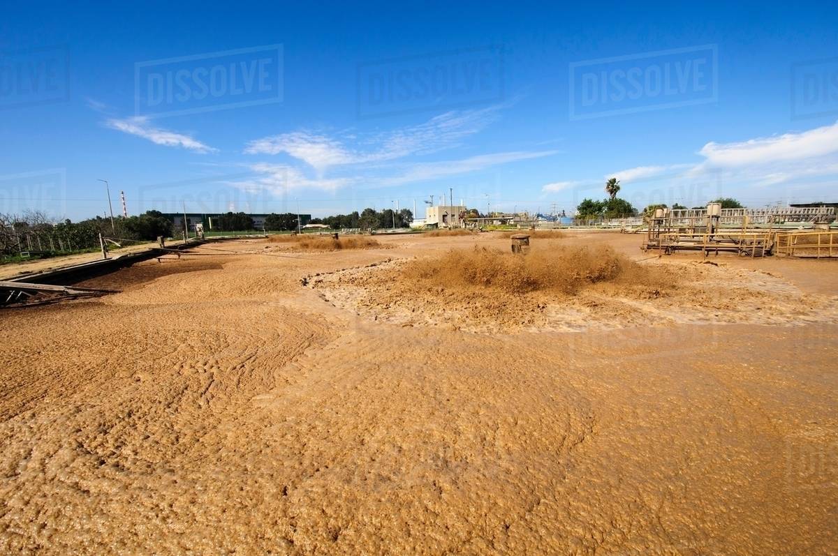 View of brown sludge treatment pool at sewage treatment plant - Royalty ...