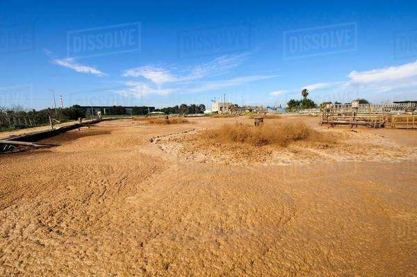 View of brown sludge treatment pool at sewage treatment plant - Royalty ...