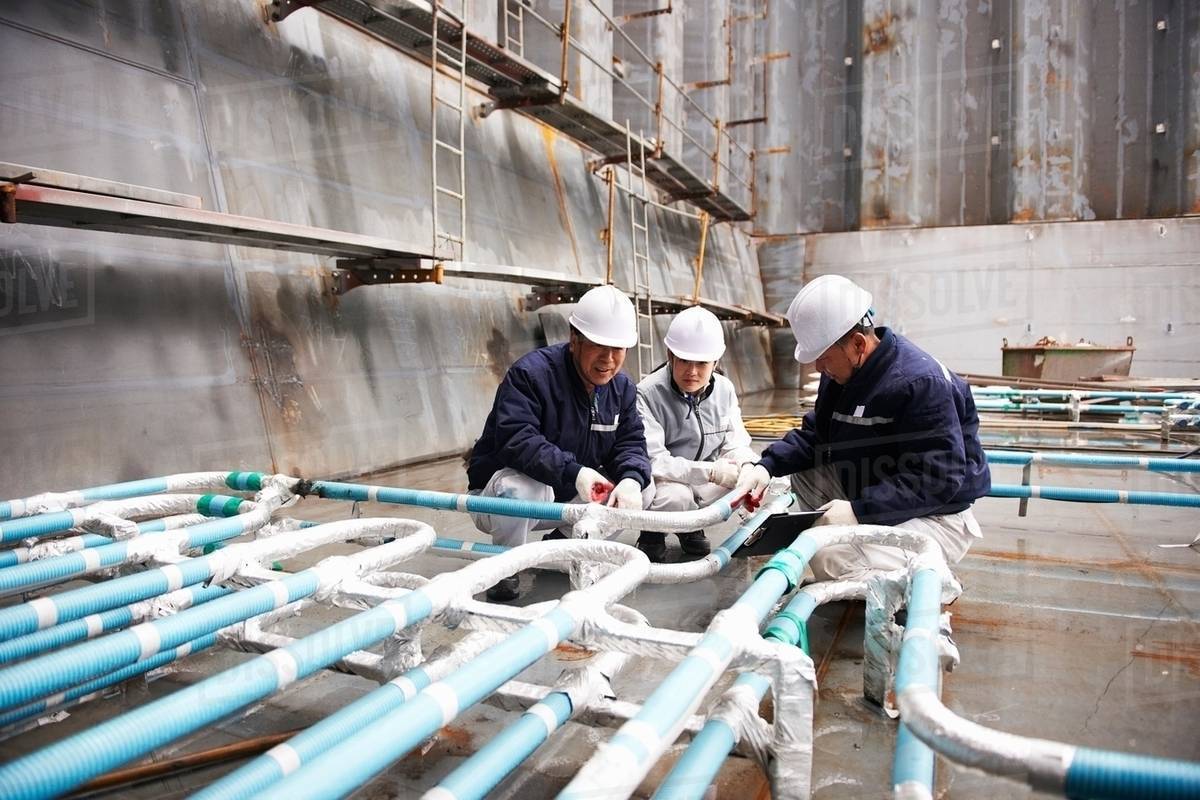 Workers checking pipework on container ship at shipyard, GoSeong-gun ...