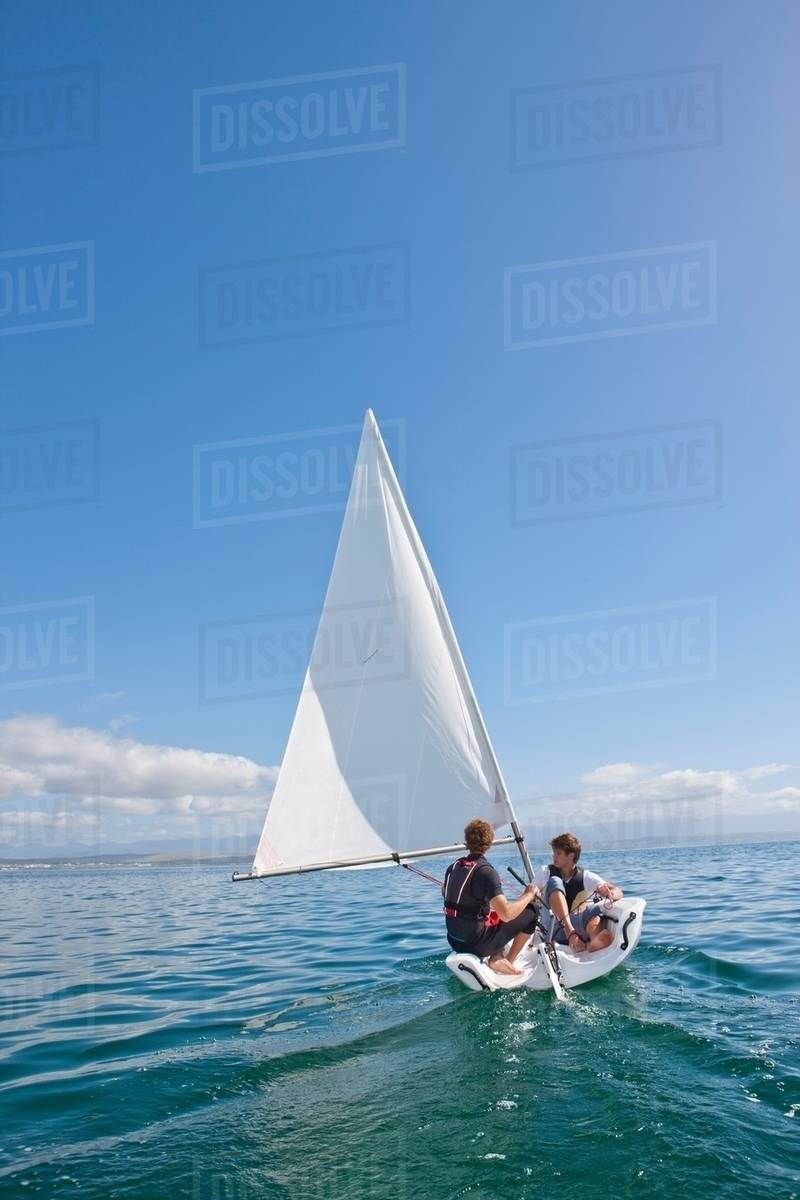 Two young men sailing out to sea - Royalty-free Stock Photo | Dissolve