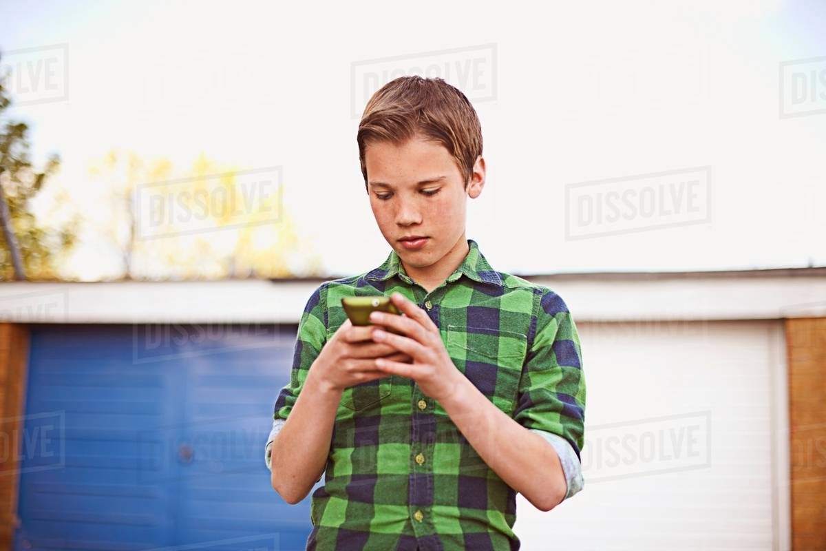 Boy using cell phone - Royalty-free Stock Photo | Dissolve