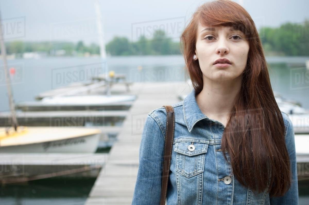 Portrait of serious young woman by lake - Royalty-free Stock Photo ...