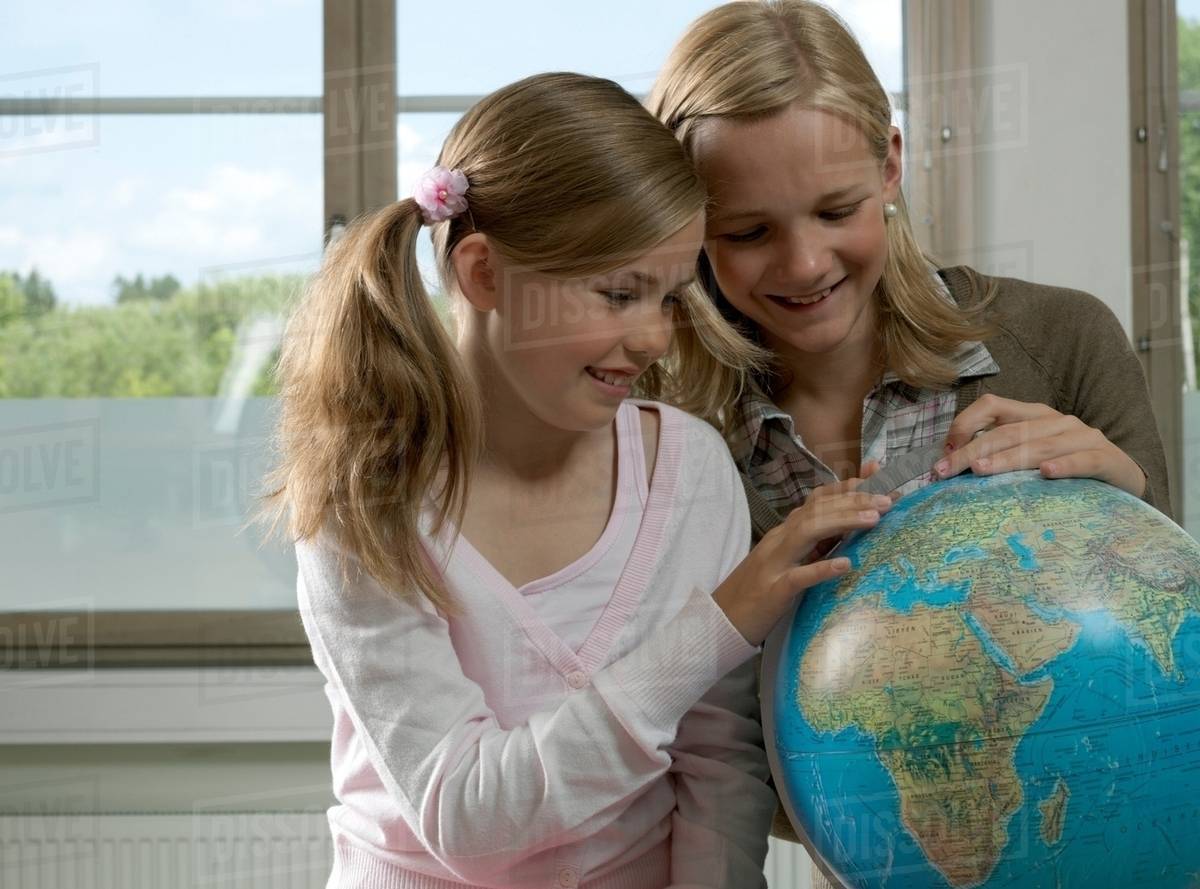 Two girls with earth globe - Royalty-free Stock Photo | Dissolve