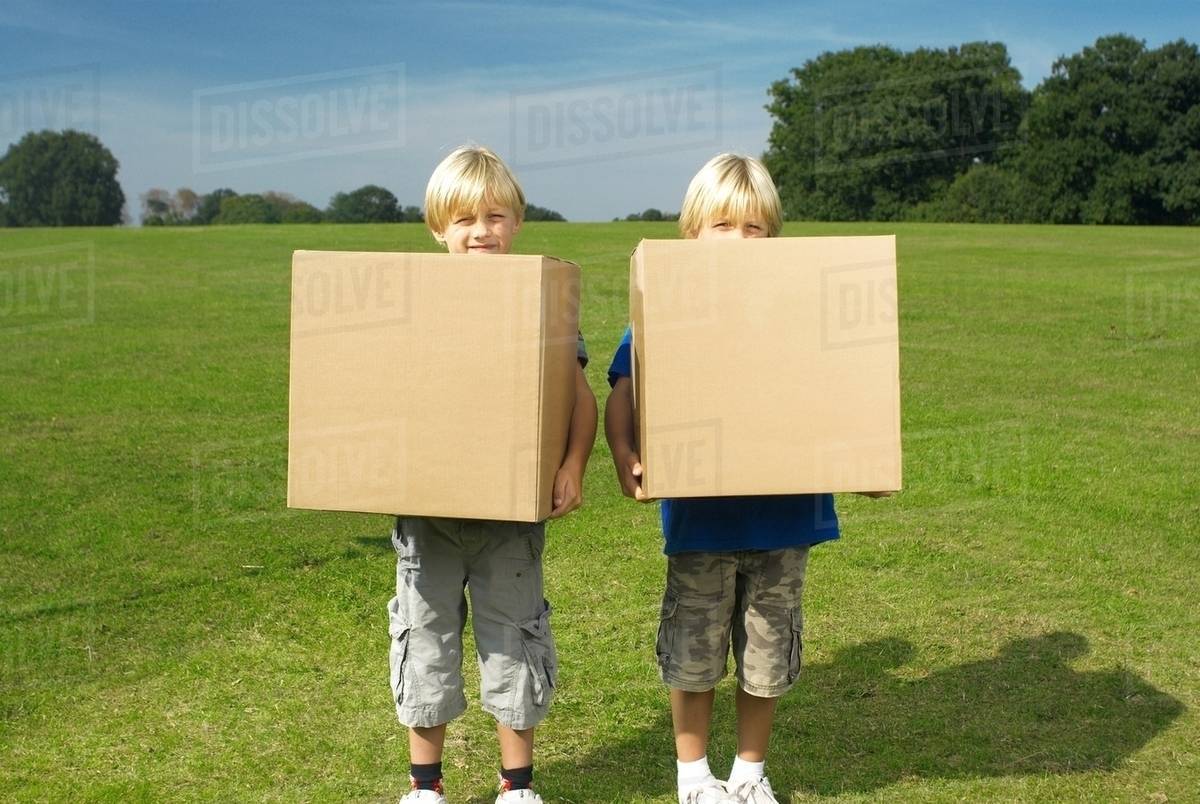 Two boys holding boxes - Stock Photo - Dissolve