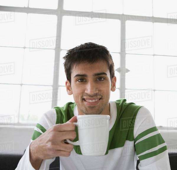 Portrait of a man holding a mug. - Stock Photo - Dissolve