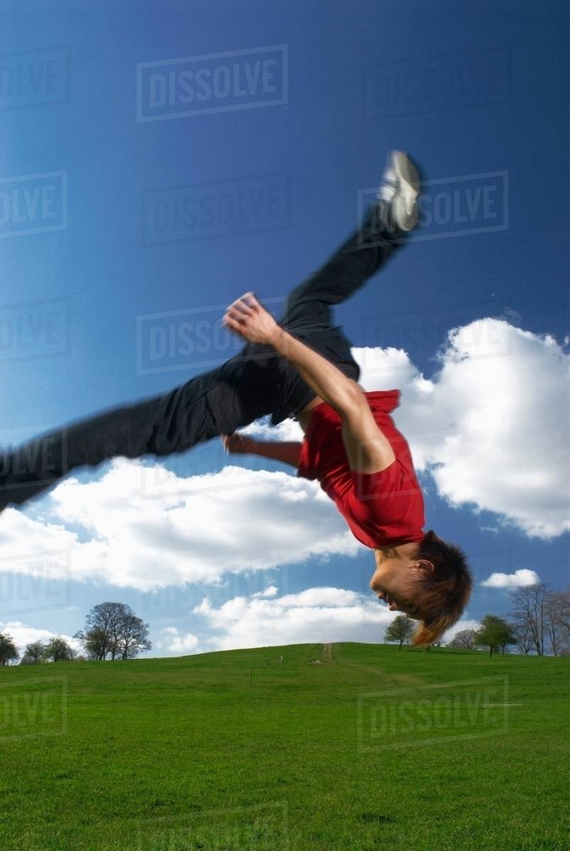 Man backflipping in park - Royalty-free Stock Photo | Dissolve
