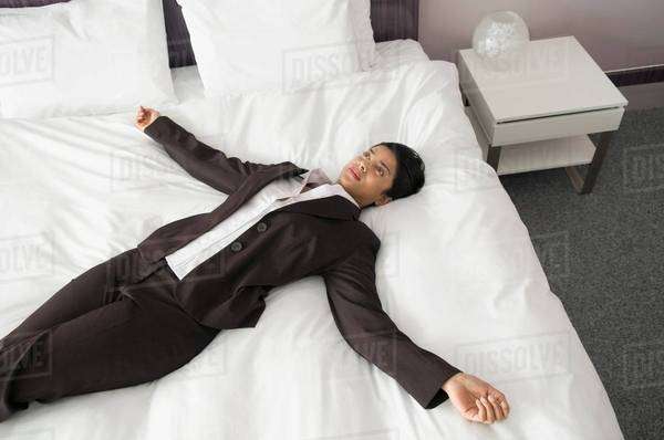 Woman on a bed with arms outstretched - Royalty-free Stock Photo | Dissolve