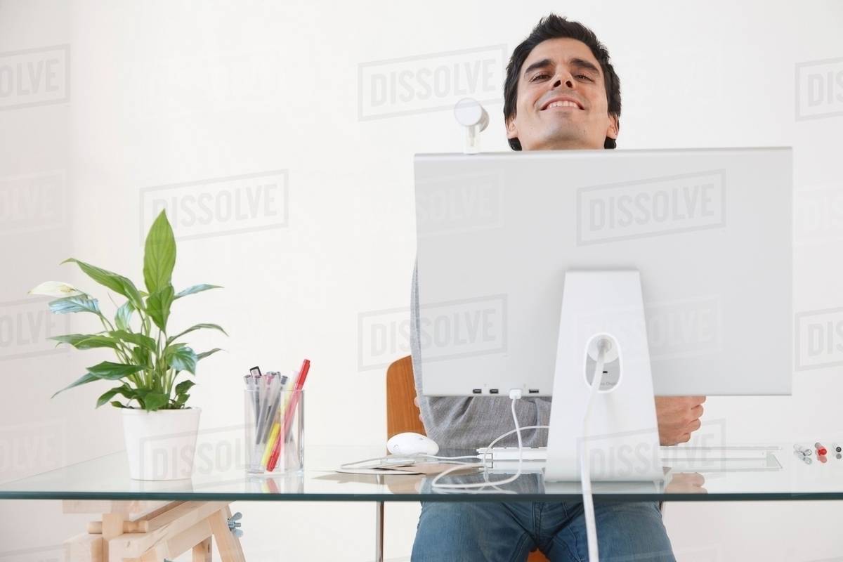 Man working at computer smiling - Royalty-free Stock Photo | Dissolve