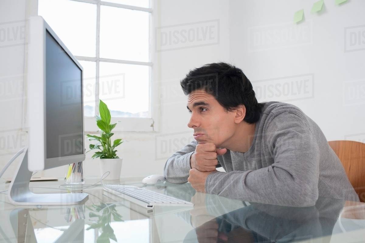 Man looking at computer - Royalty-free Stock Photo | Dissolve