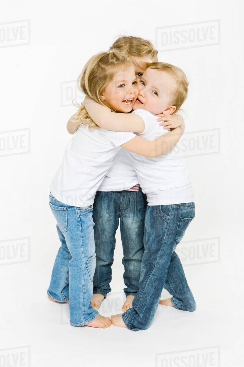 Three toddler girls hugging - Stock Photo - Dissolve