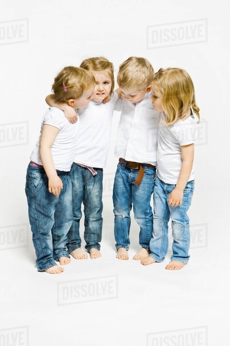 Four toddlers hugging - Stock Photo - Dissolve