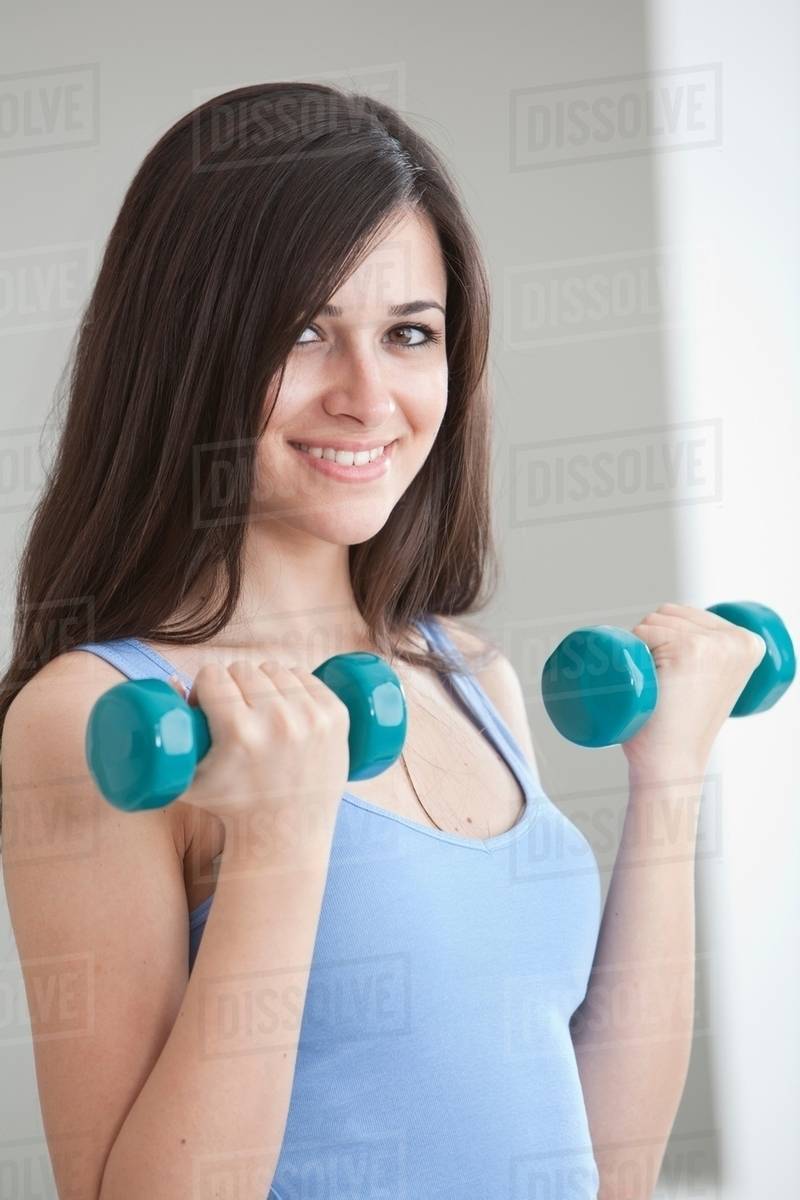 Woman lifting hand weights - Stock Photo - Dissolve