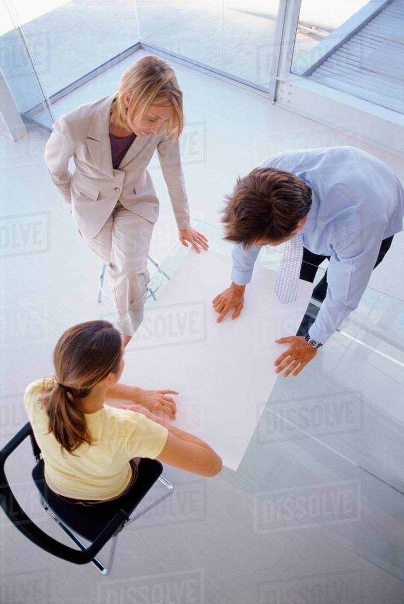 Business people examining plans - Royalty-free Stock Photo | Dissolve