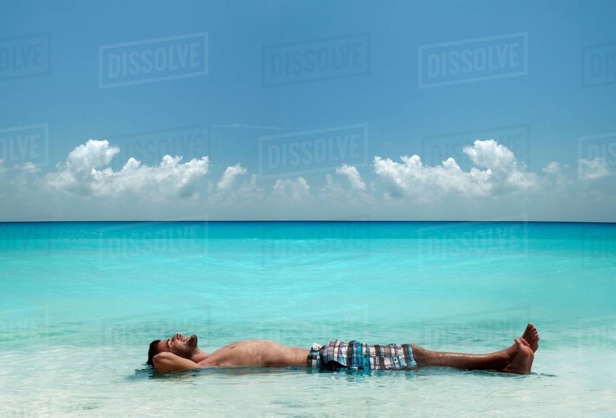 Man floating in water at tropical beach - Royalty-free Stock Photo ...