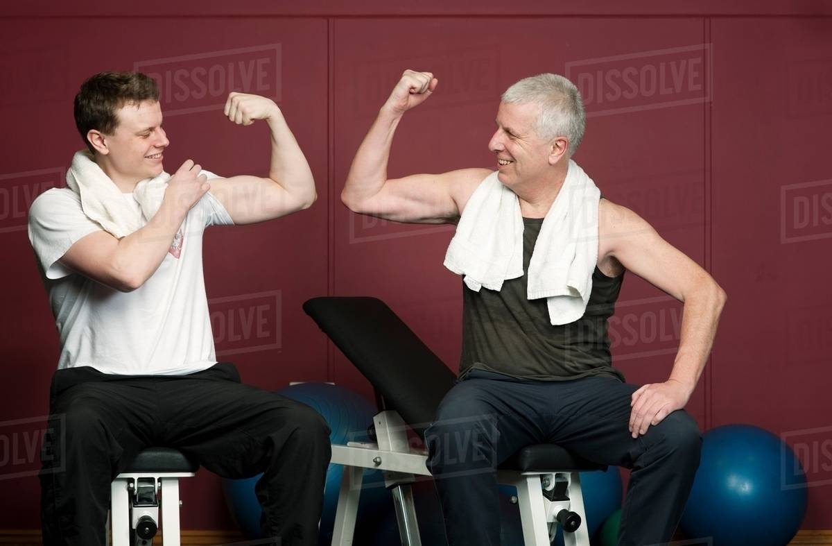 Father and son flexing muscles in gym - Royalty-free Stock Photo | Dissolve