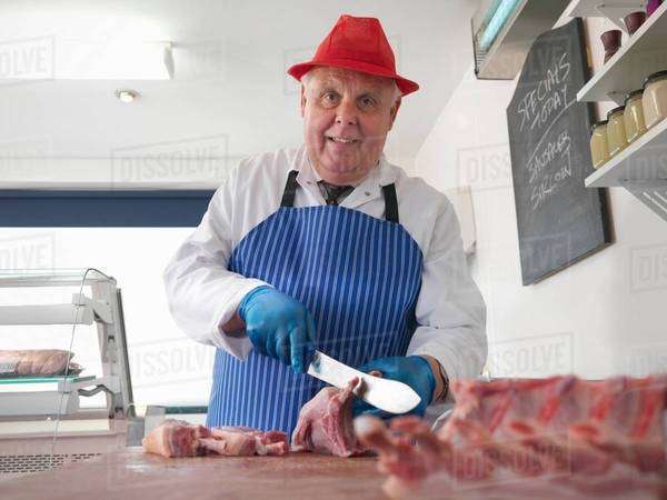 Butcher carving meat in shop - Stock Photo - Dissolve