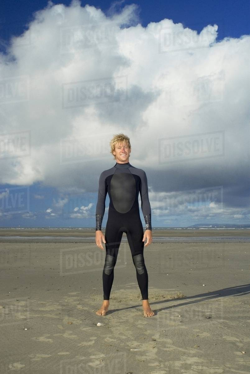 Surfer standing on beach - Royalty-free Stock Photo | Dissolve