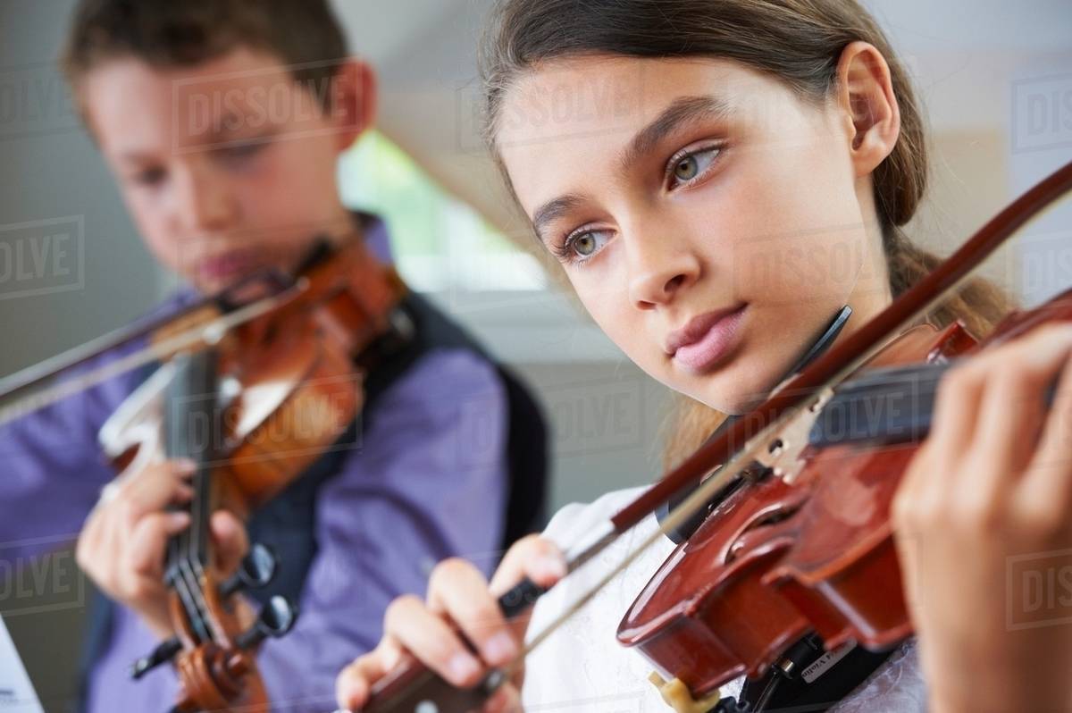 Serious children playing violin - Stock Photo - Dissolve