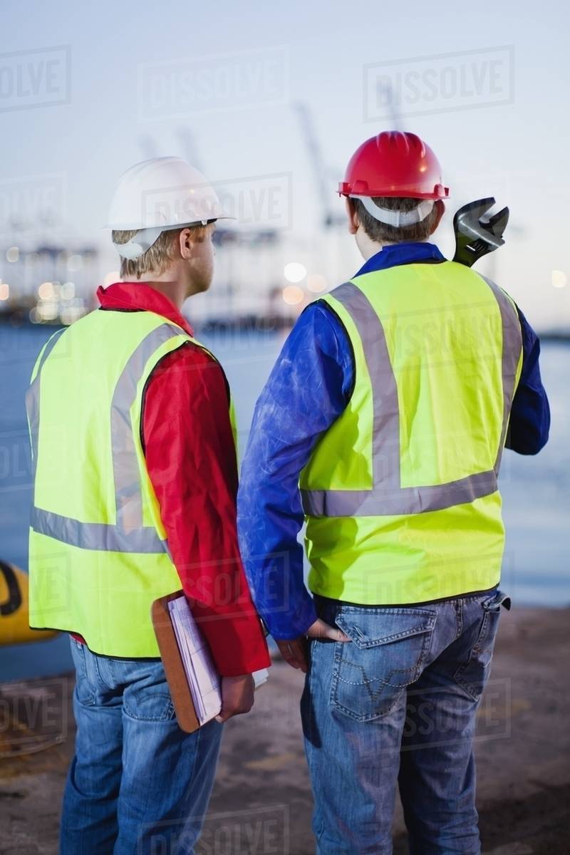 Workers standing together in shipyard - Royalty-free Stock Photo | Dissolve