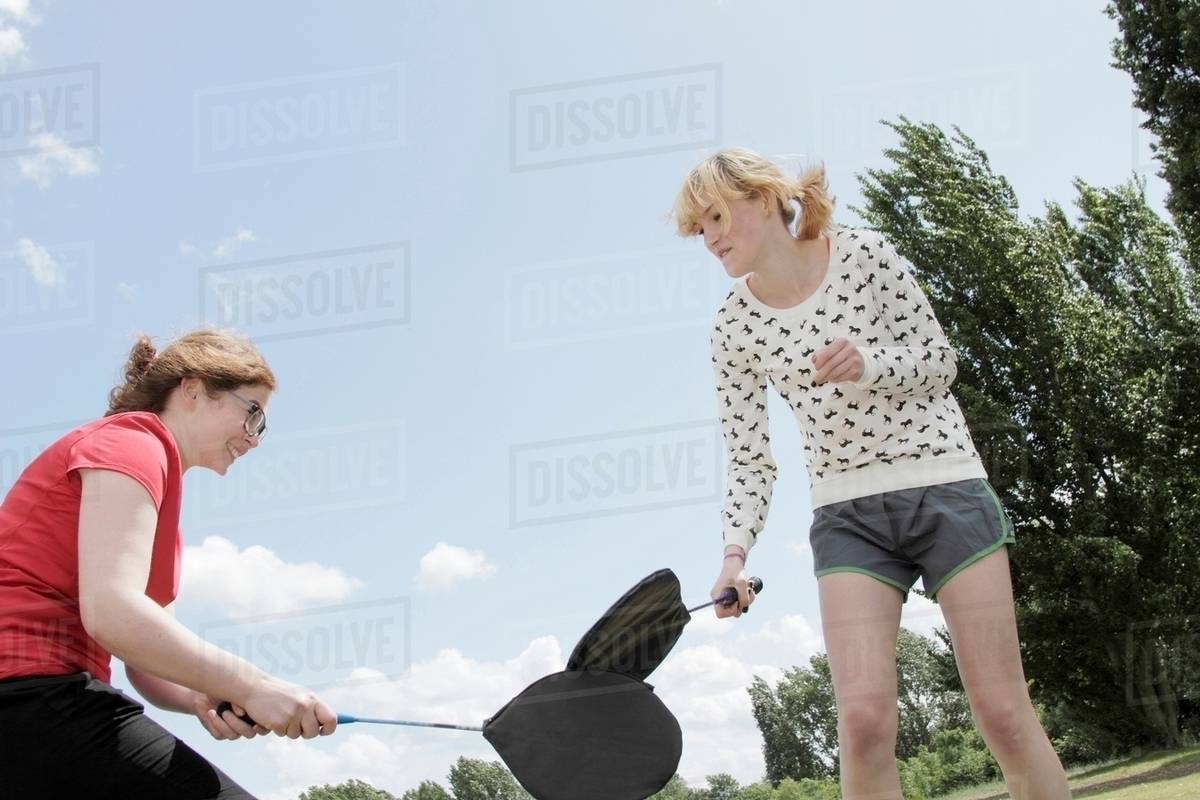 Girls playing with rackets in park - Stock Photo - Dissolve