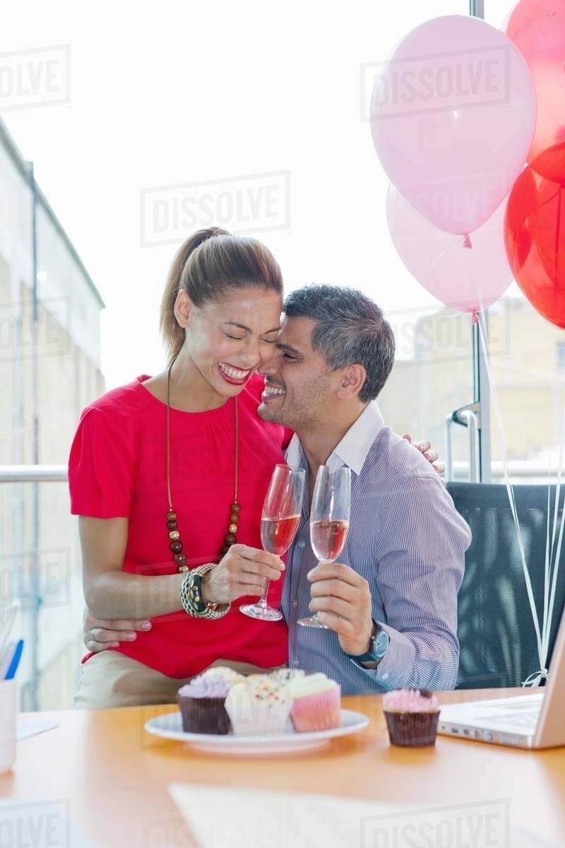 Business people hugging at office party - Stock Photo - Dissolve